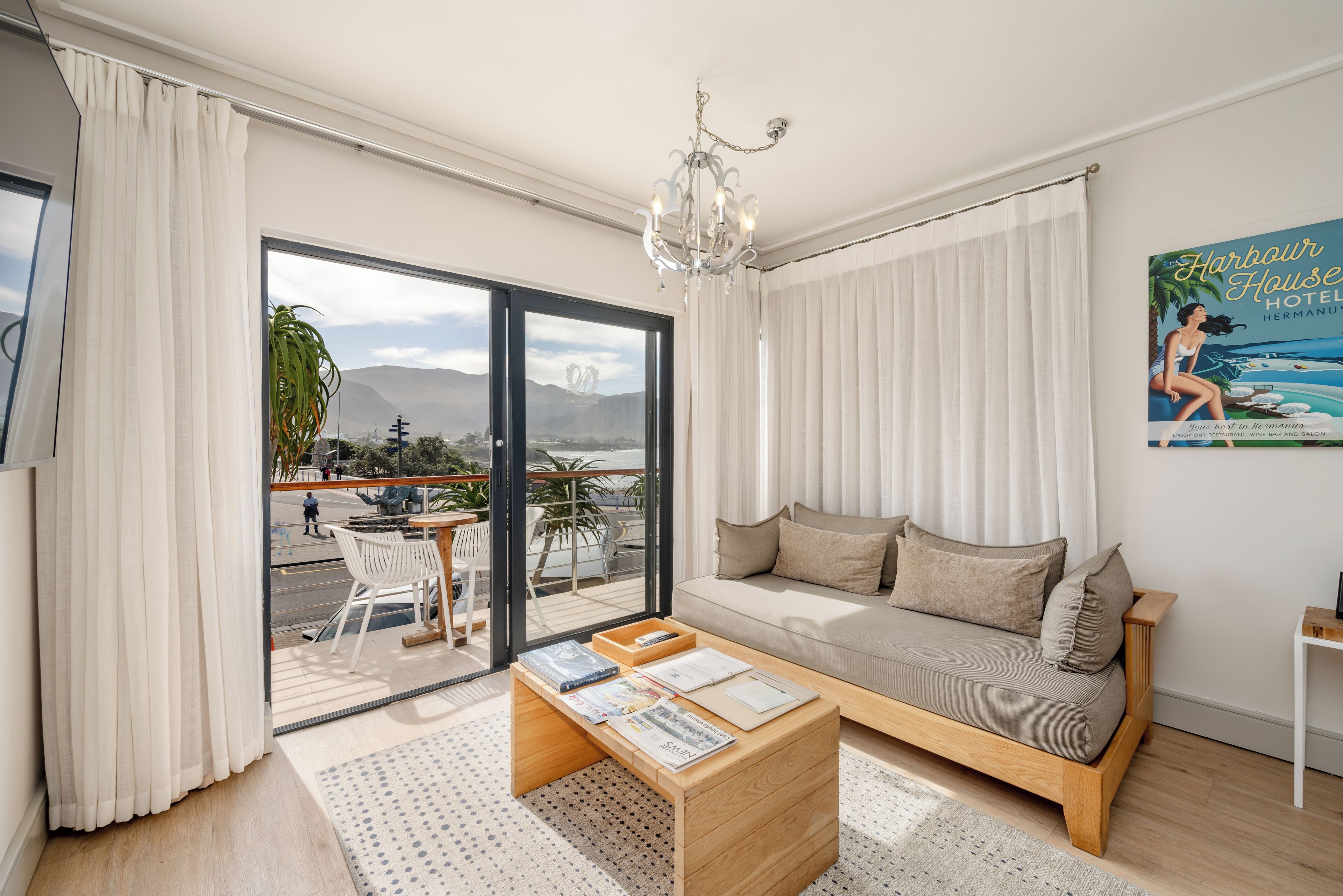 Sala de estar moderna com sofá, mesa de centro e vista para o exterior por uma porta de correr de vidro.