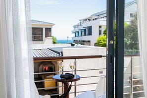 Uma varanda com uma mesa, dois copos de vinho branco e uma câmera.