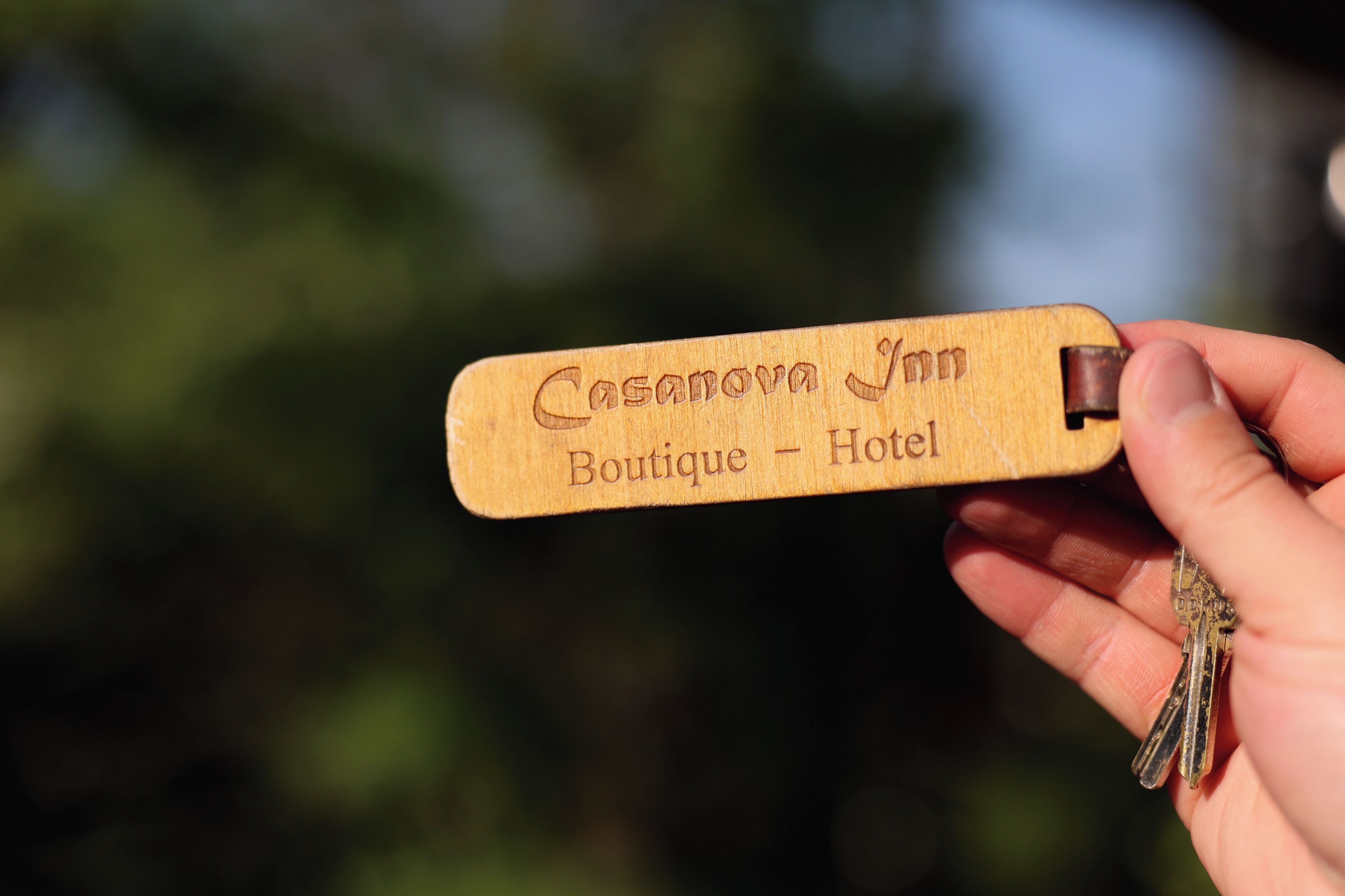 Um porta-chaves de madeira com a inscrição 'Casanova Inn Boutique - Hotel'.