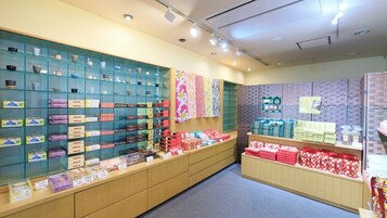 Uma loja com prateleiras de produtos embalados, uma exposição de artigos decorativos e uma parede estampada.