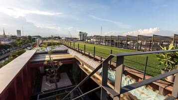 Terraço no telhado com vista para a paisagem urbana, incluindo edifícios e um estádio.