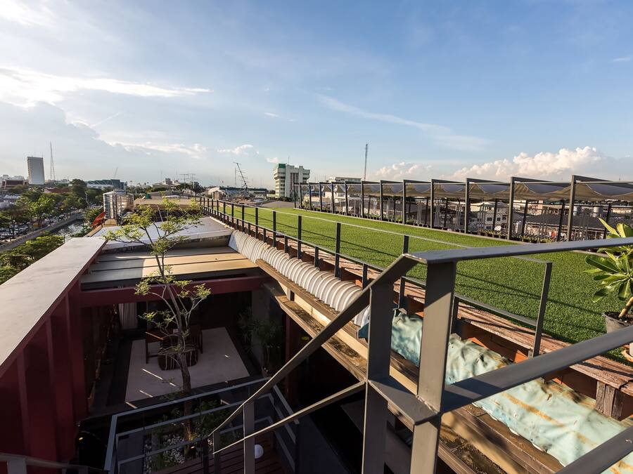 Terraço no telhado com vista para a paisagem urbana, incluindo edifícios e um estádio.