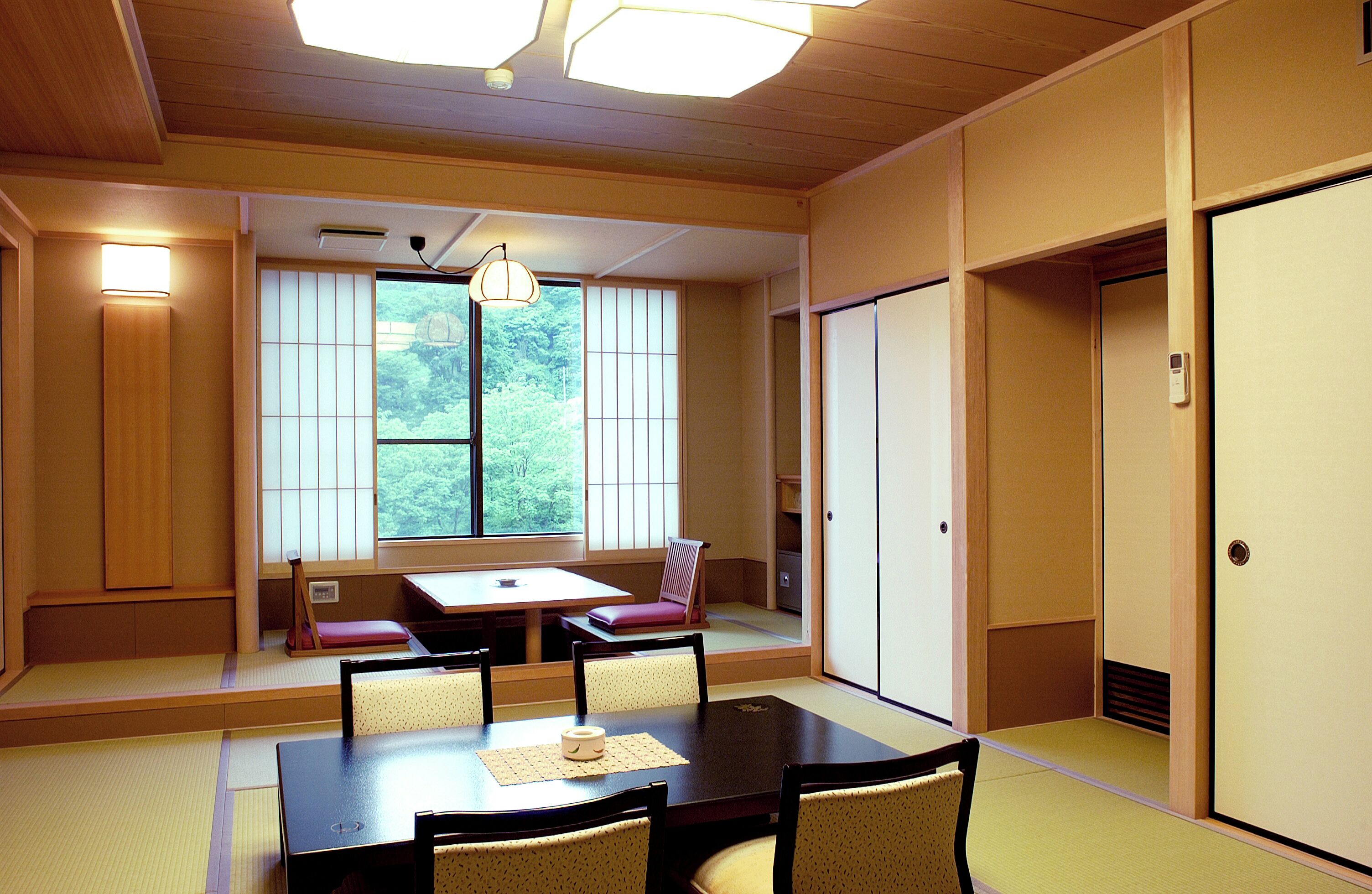 Um quarto japonês tradicional, com chão de tatame, uma mesa baixa e portas deslizantes.