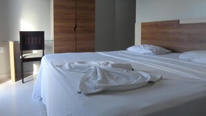 Quarto de hotel com uma cama grande, um guarda-roupa de madeira e uma cadeira de design exclusivo.