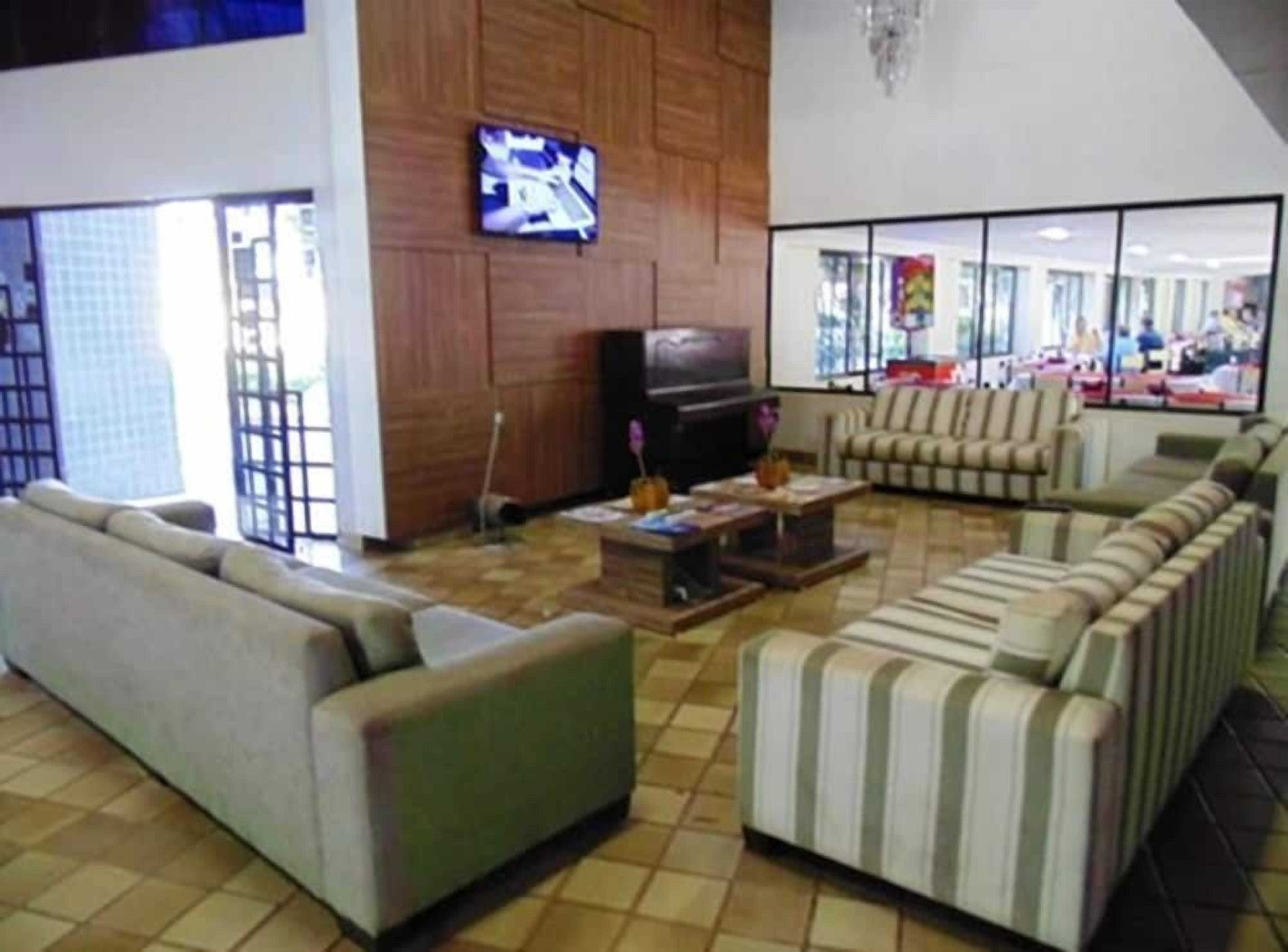 Uma sala de estar ampla com sofá, televisão e mesa de centro.