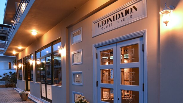 Um edifício com uma placa que diz 'Leonidion Guest House'.