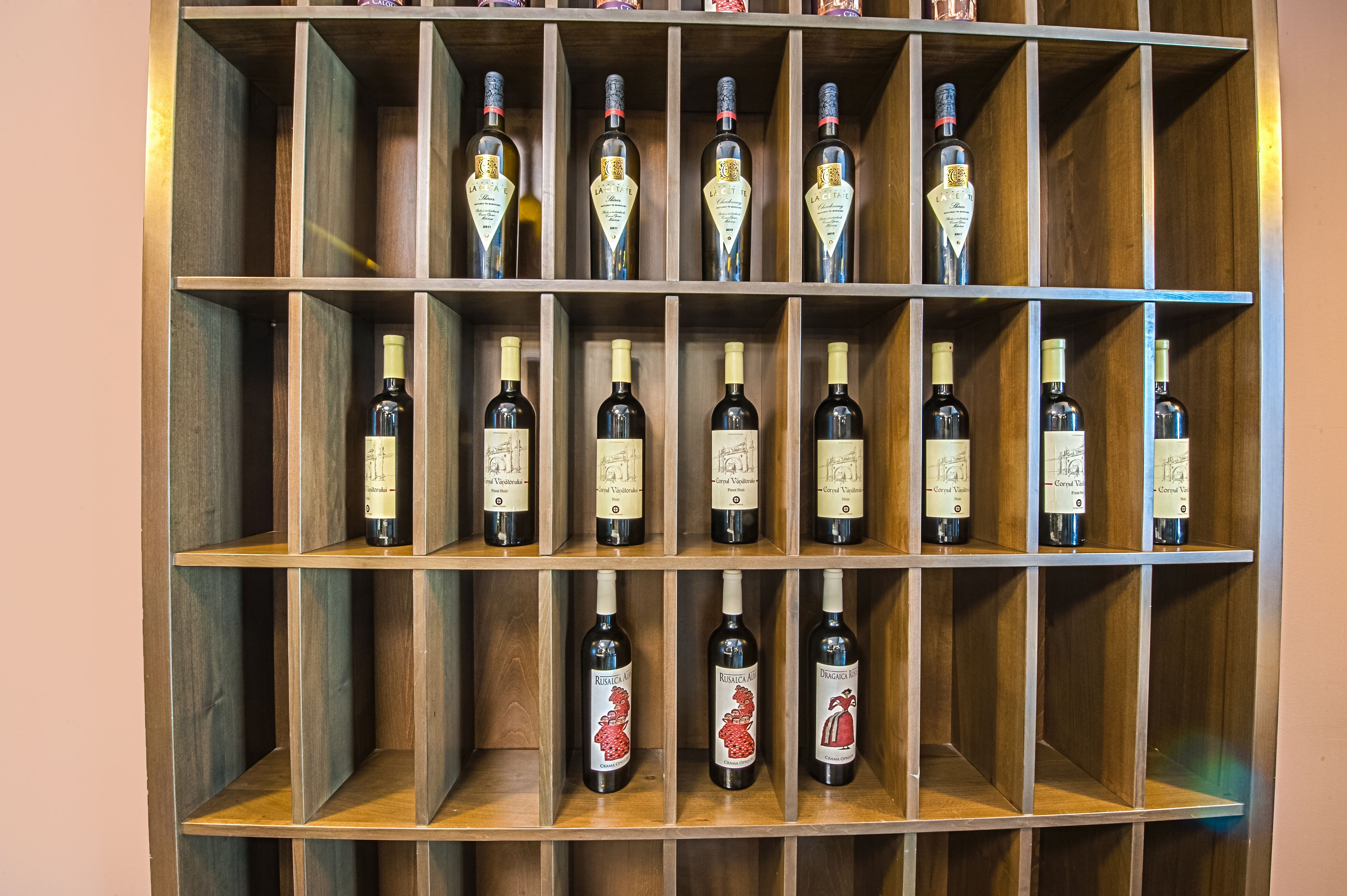 Uma estante de madeira para vinhos com várias garrafas.