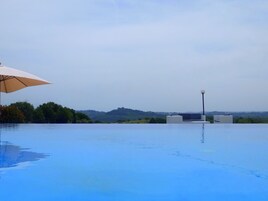 Piscina externa, piscina infinita, guarda-sóis, espreguiçadeiras