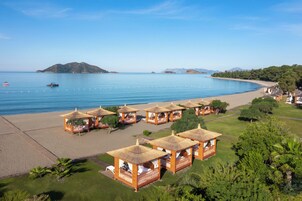 Na praia, espreguiçadeiras, guarda-sóis de praia, toalhas de praia 