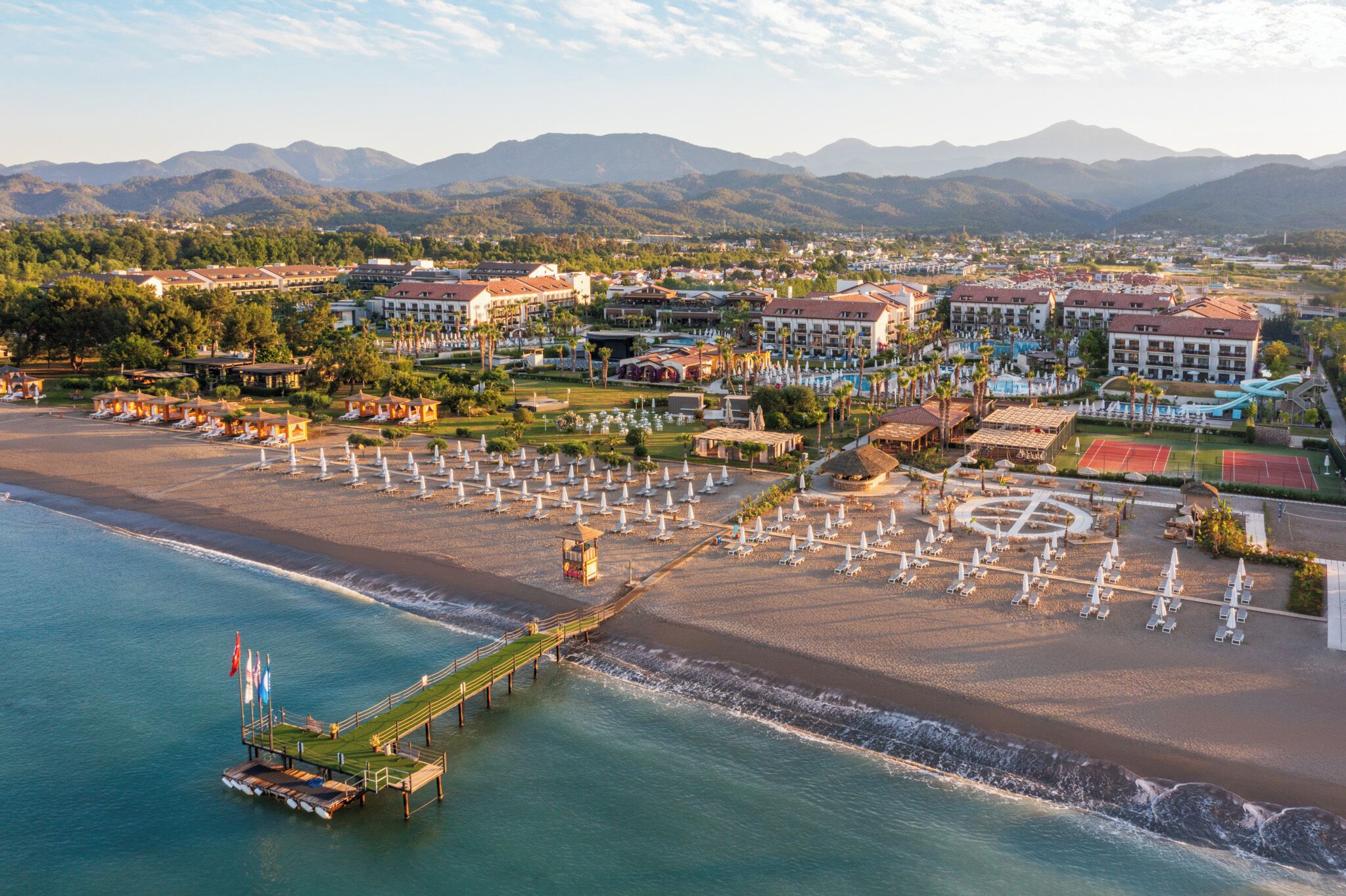 Na praia, espreguiçadeiras, guarda-sóis, toalhas de praia 