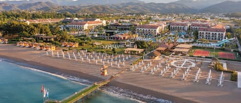 Na praia, espreguiçadeiras, guarda-sóis, toalhas de praia