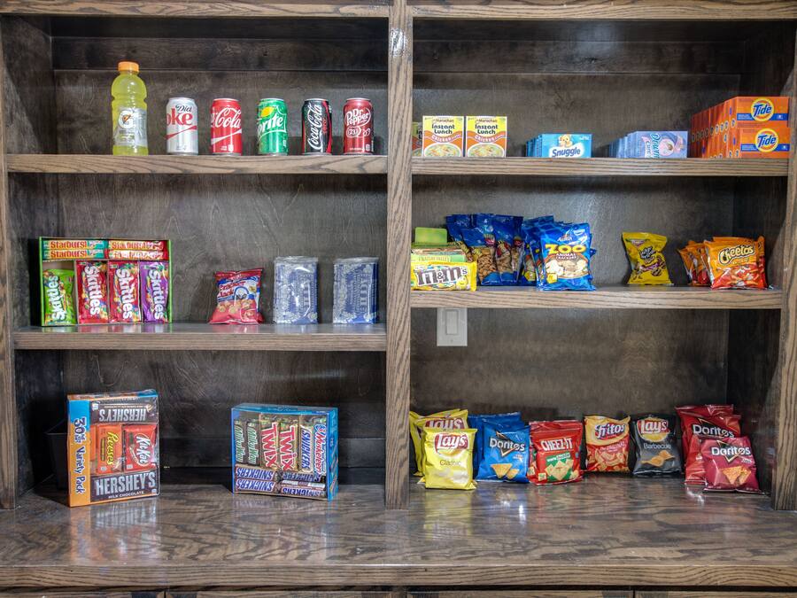 Uma prateleira com diversos snacks e bebidas embaladas.