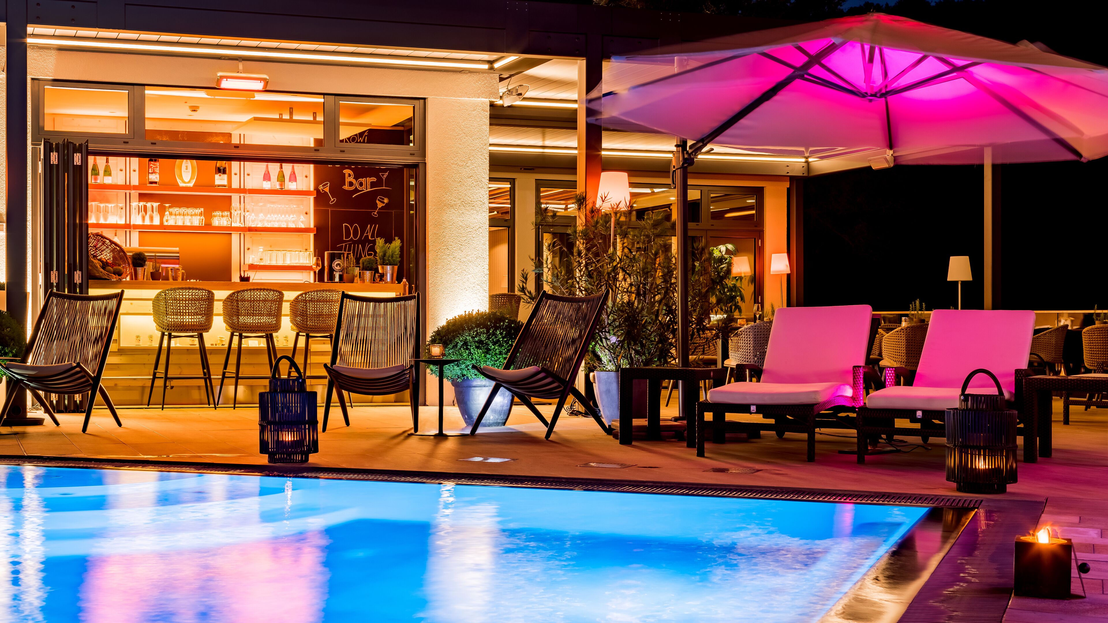 Uma área na piscina com espreguiçadeiras, um bar e uma piscina.