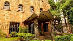 Um edifício de pedra com janelas em arco e entrada coberta.