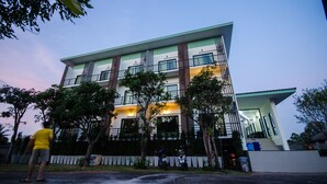 Um edifício de vários andares com telhado plano, janelas amplas e uma varanda.