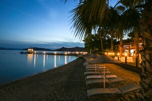 Uma praia privada, espreguiçadeiras, guarda-sóis de praia 