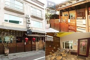 Um edifício tradicional japonês com fachada de madeira, entrada coberta e uma pequena área externa com mesas e cadeiras.