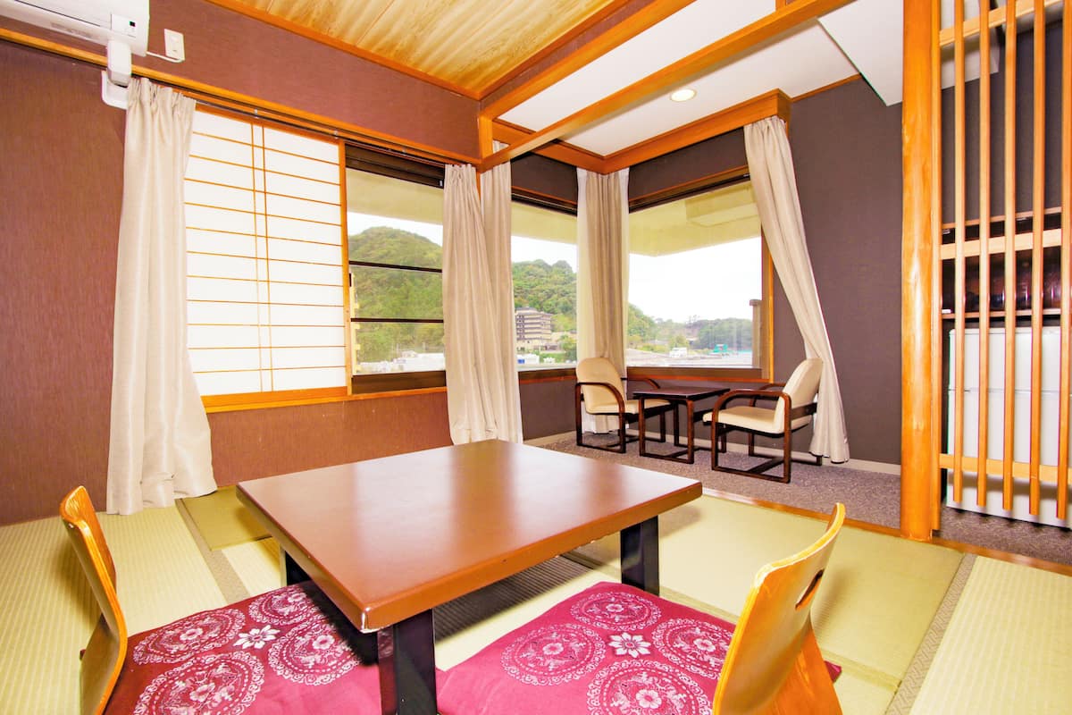 Um quarto em estilo japonês tradicional, com tatames, uma mesa baixa e biombos shoji.
