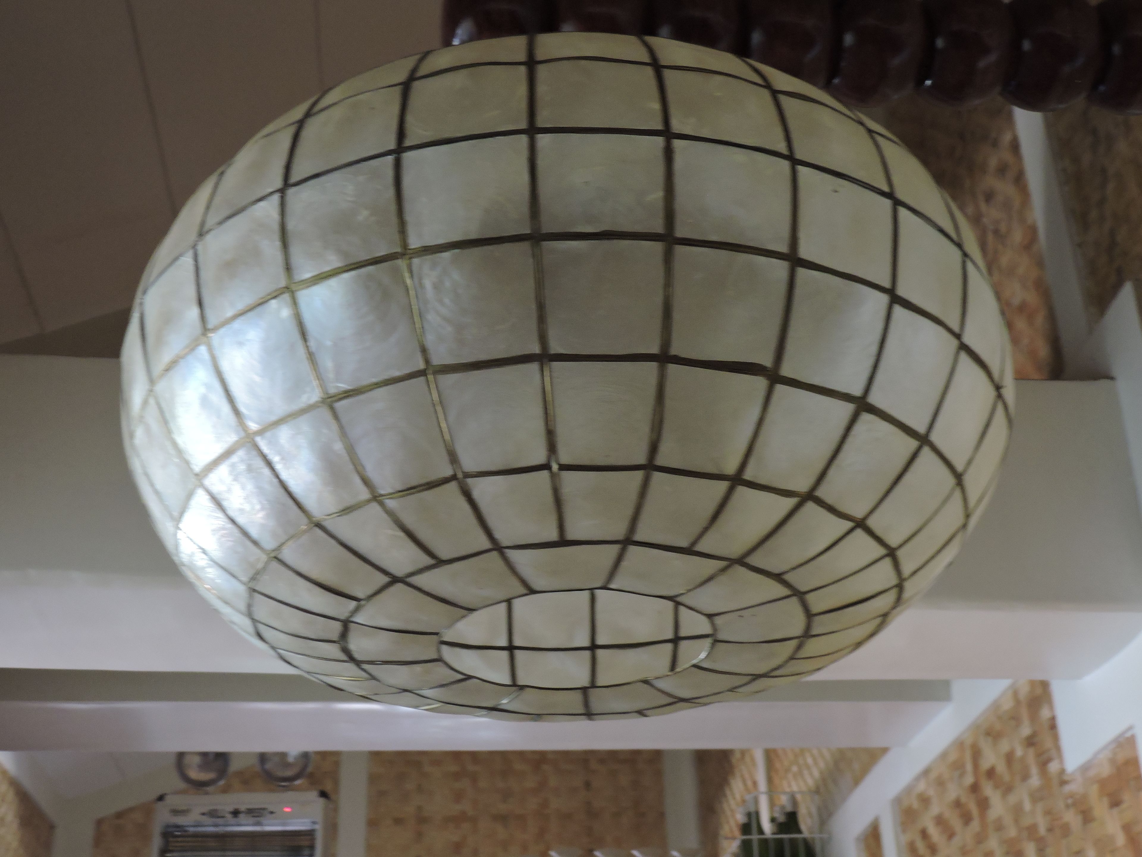 Luminária pendente esférica com padrão de grade.