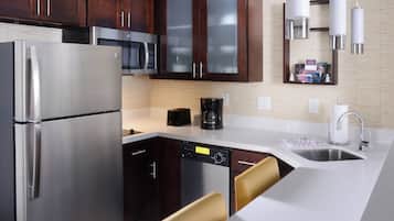 Um frigorífico/congelador grande, um micro-ondas, uma placa de cozinha