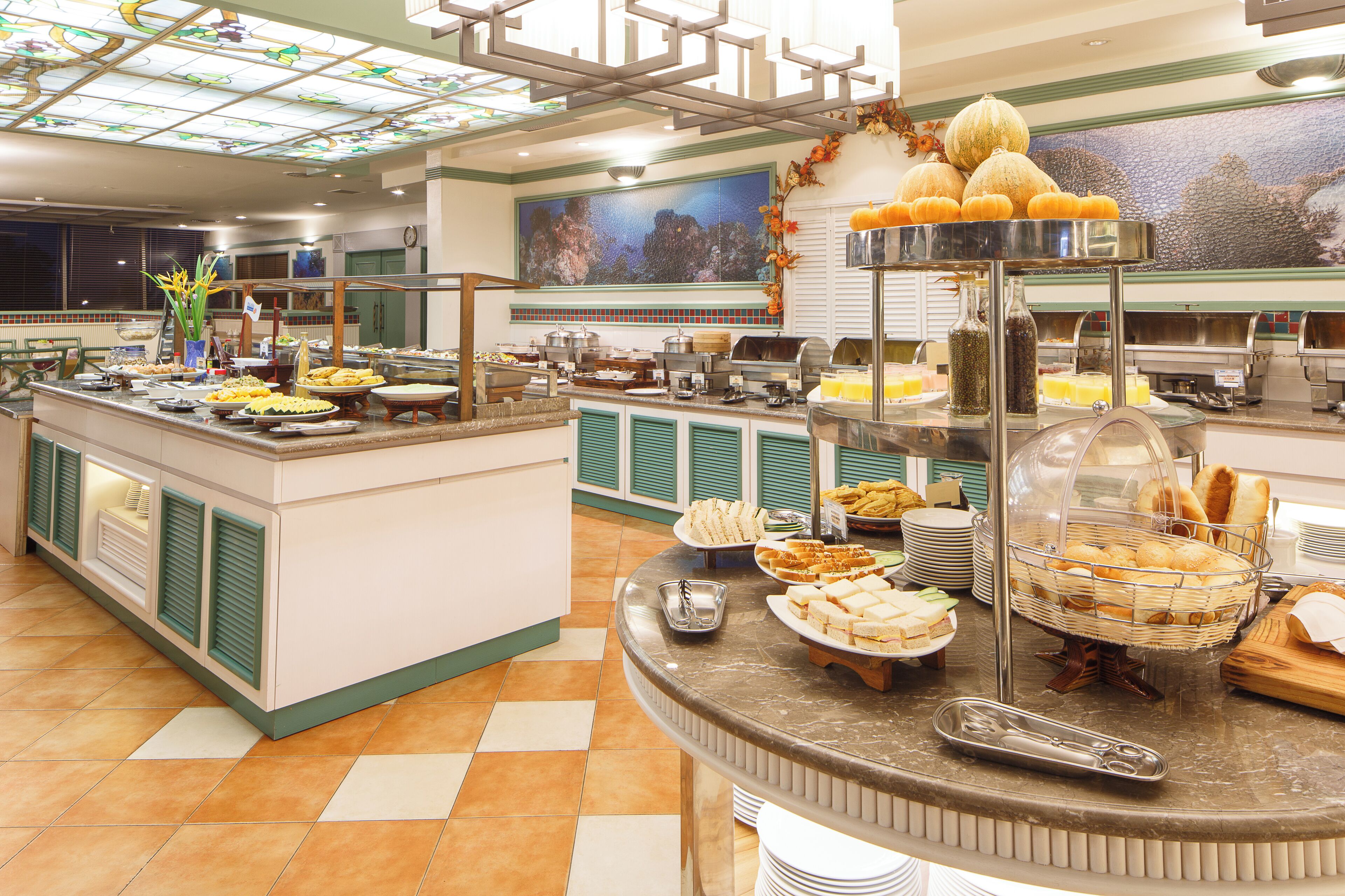 Buffet com diversos alimentos e um arranjo decorativo.
