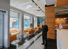 Um hall de hotel moderno, com balcão de recepção, área de estar e grandes janelas.