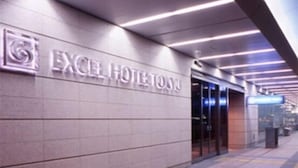 Entrada de um hotel com uma placa indicando 'EXCEL HOTEL'.