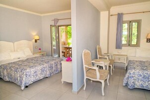 Quarto de hotel com duas camas, uma escrivaninha e uma cadeira.