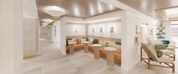 Um interior moderno com uma área de recepção, assentos com mesas redondas e vista para o exterior.