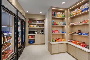 Uma despensa bem organizada, com prateleiras repletas de petiscos, bebidas e temperos.