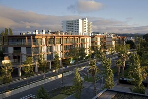 Um edifício moderno de vários andares com telhado plano, janelas amplas e uma combinação de vidro e concreto.