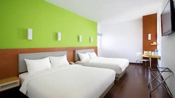 Quarto de hotel com duas camas, uma escrivaninha, uma cadeira, uma televisão e uma TV na parede.