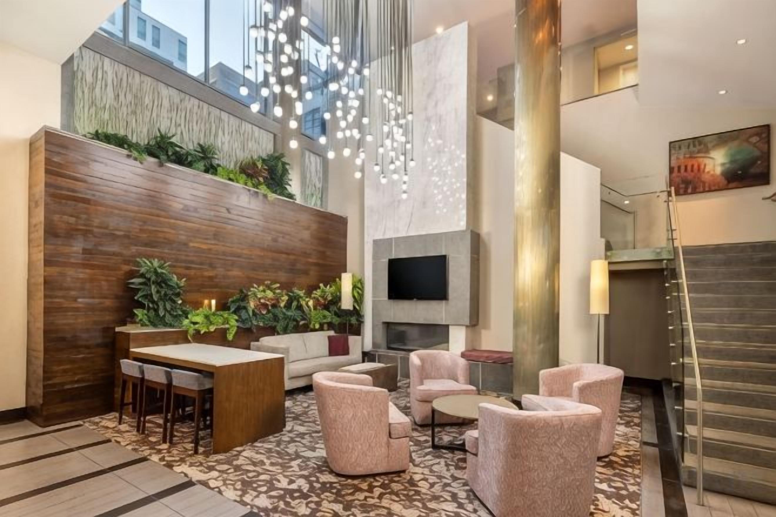 Um lobby moderno com área de estar, televisão de tela plana e escada.