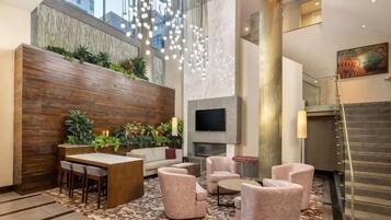 Um lobby moderno com área de estar, televisão de tela plana e escada.