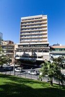Um hotel com vários andares e um pátio central, rodeado por outros edifícios.