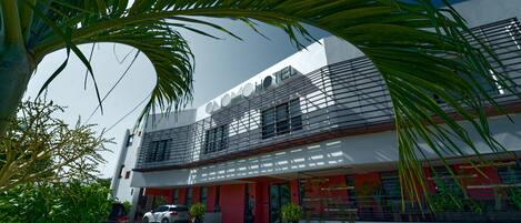 Um hotel moderno com estrutura em dois andares, área externa coberta e calçada pavimentada.