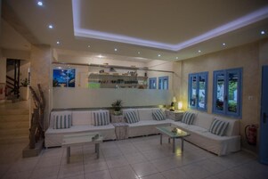 Uma sala de estar moderna com um sofá, uma mesa de centro e uma cozinha com prateleiras e uma janela.