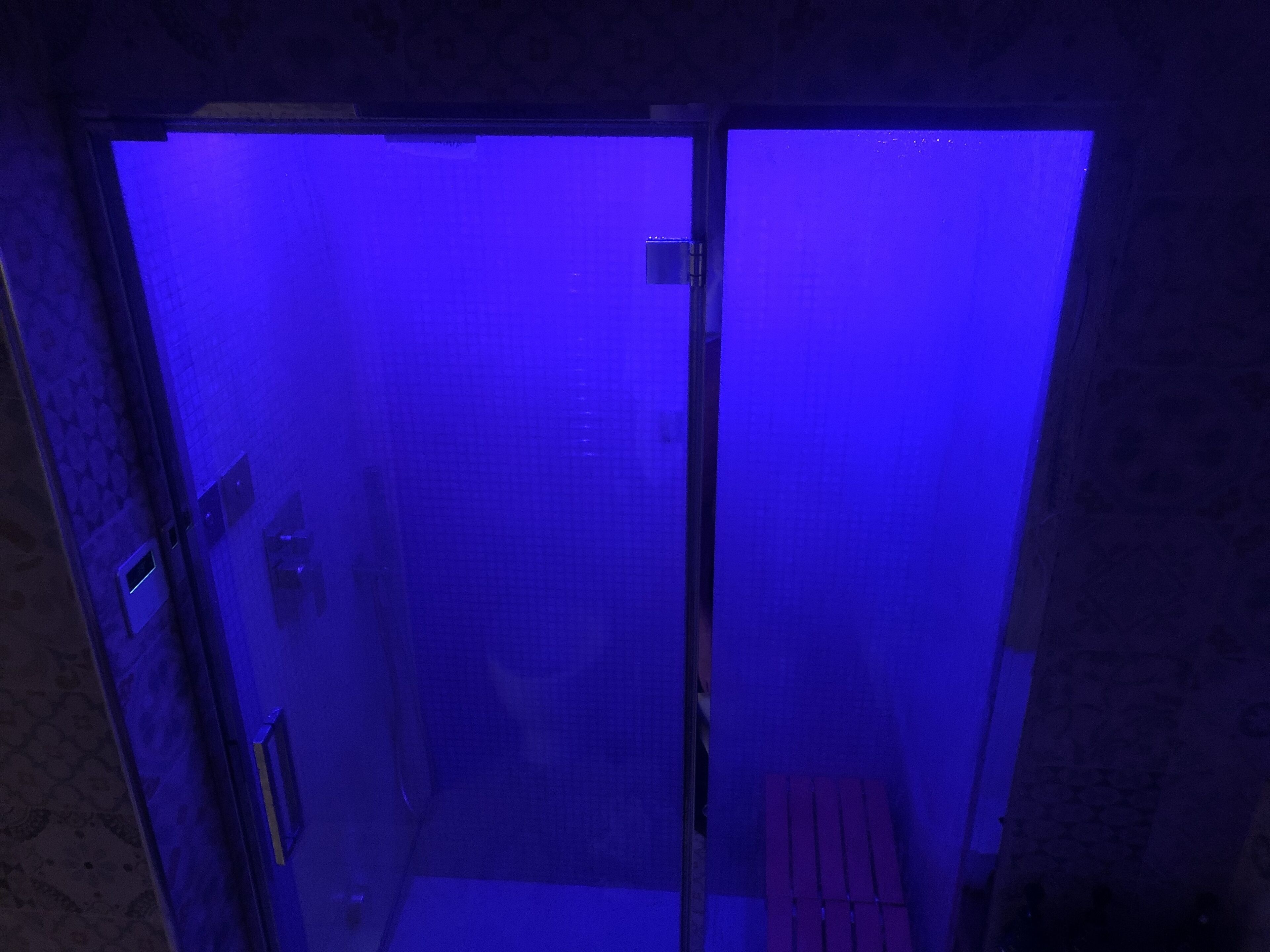 Um quarto com soalho em azulejos e uma porta.