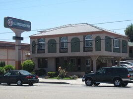 Um edifício de dois andares com uma placa que diz 'El Rancho Inn'.