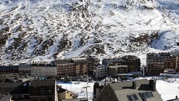 Uma cidade nas montanhas coberta de neve, com edifícios e uma pista de esqui.