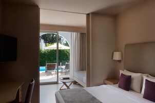 Quarto de hotel com uma cama, uma escrivaninha e vista para a área da piscina.