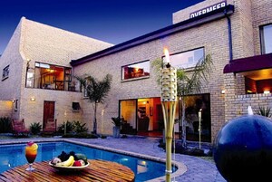 Um hotel moderno com área de piscina, espaço para sentar ao ar livre e entrada bem iluminada.