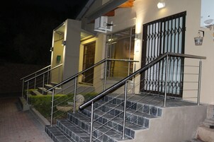 Um edifício moderno com uma escadaria que leva a uma porta com portão de metal.