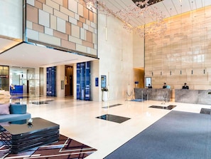 Um hall amplo com balcão de recepção, área de estar e design arquitetônico moderno.
