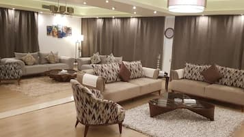 Apartamento Deluxe, 3 quartos | Sala | Televisor de ecrã plano de 64 polegadas com canais via satélite