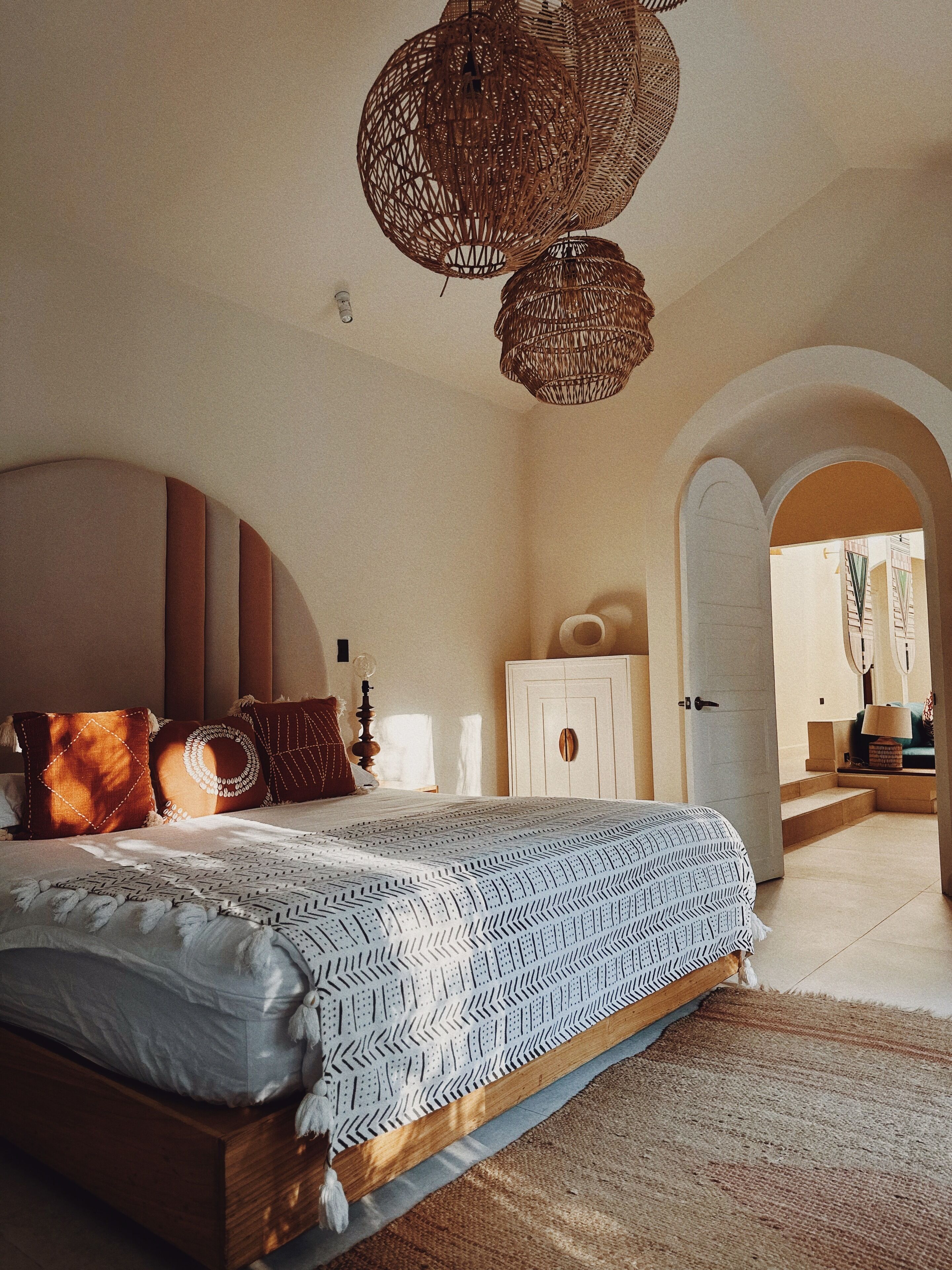 Quarto com uma cama grande, um guarda-roupa e uma cesta suspensa.