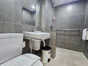 Casa de banho moderna com uma banheira branca, lavatório e zona de duche.