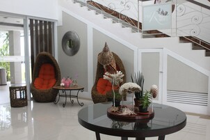 Um interior moderno com uma mesa de vidro, duas cadeiras com estampa de leopardo, uma escada e conchas decorativas.