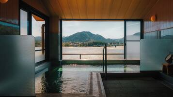 Quarto com grande janela com vista para a água e uma montanha.