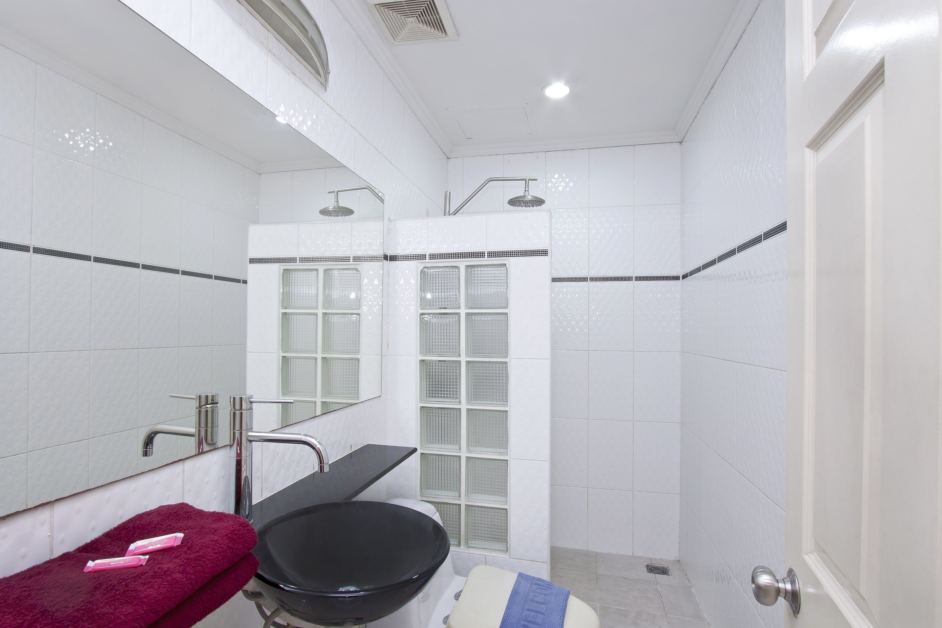 Uma casa de banho moderna com uma banheira preta, um lavatório com espelho e uma área de duche.